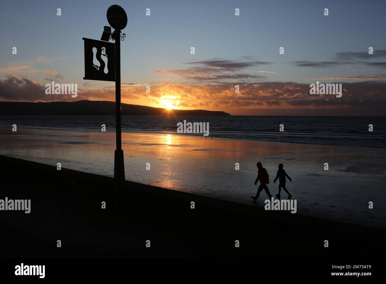 Ayr, Ayrshire, Scotland. UK Jan 2023 .Two silhouetted people walk ...