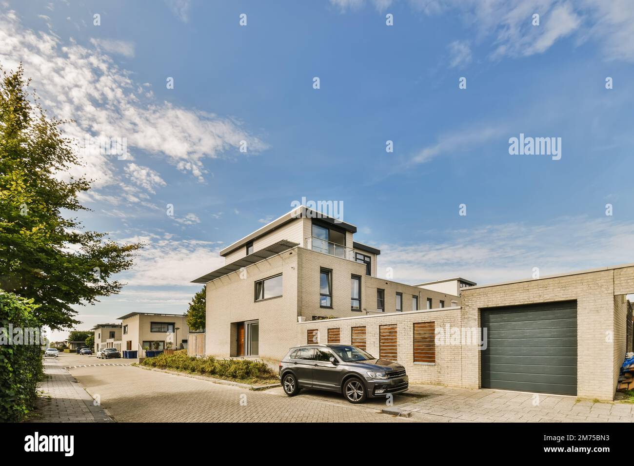 a house with a car parked in the driveway and two garages on either ...