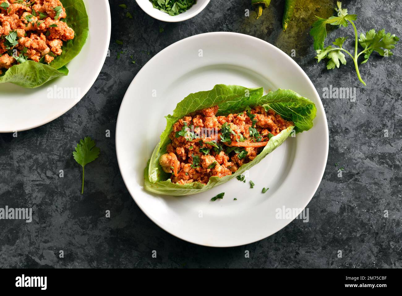 Asian minced meat lettuce wraps over dark stone background. Top view ...