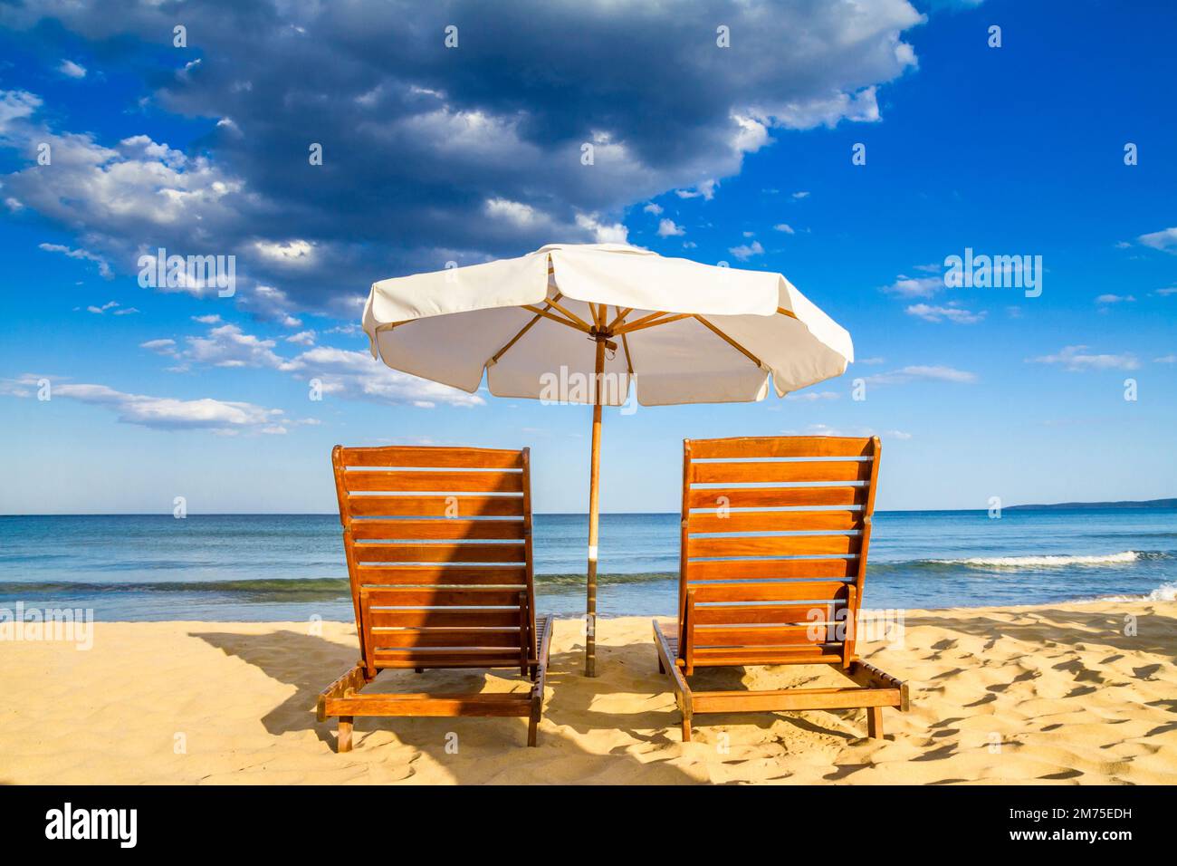 Coastal landscape - Beach umbrellas and loungers on the sandy seashore ...