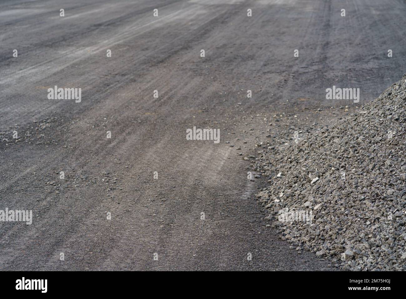 Repair of road with pile of construction debris left after the removal ...