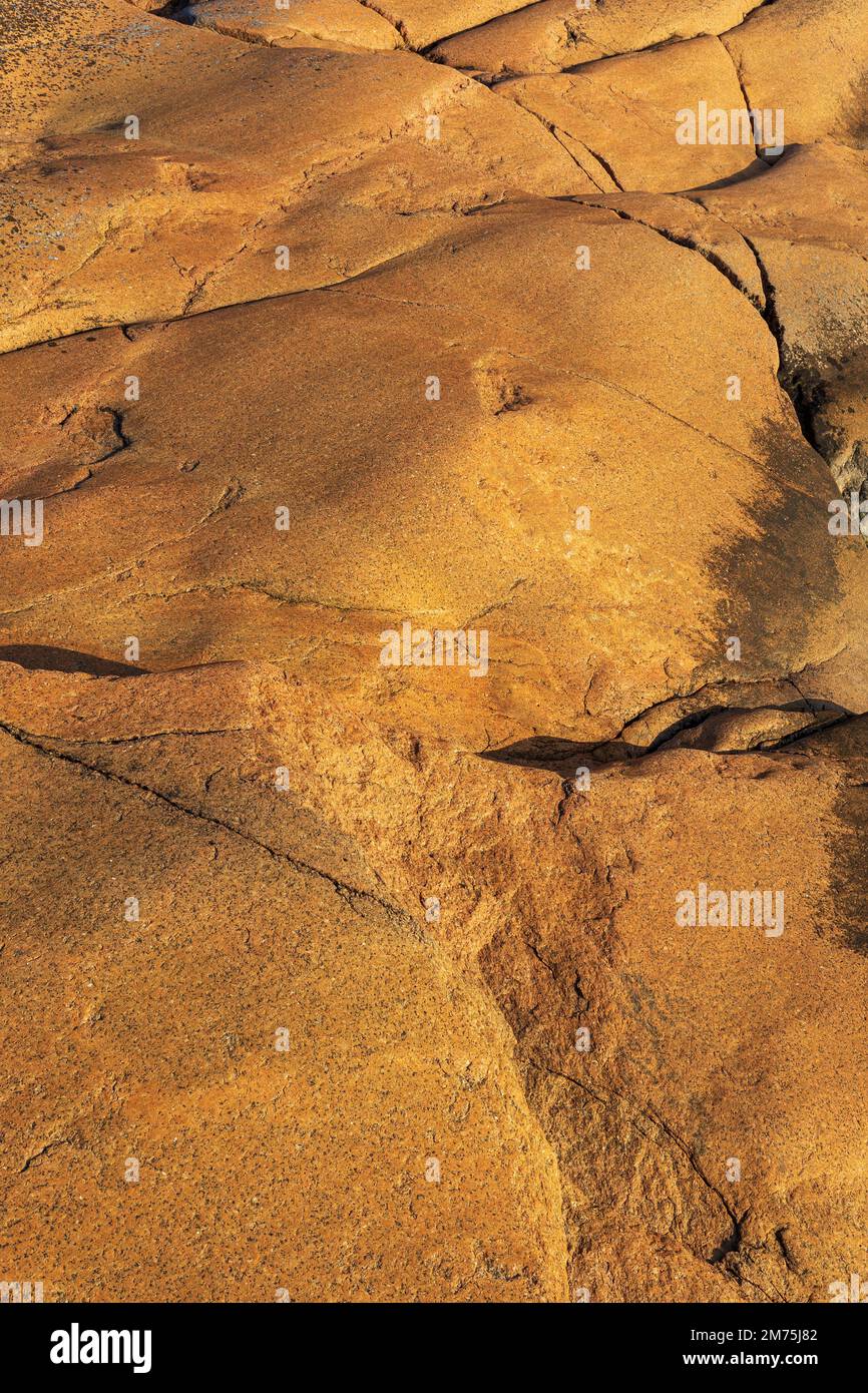 Smooth, uneven and cracked rock or cliff on a sunny day. Abstract full ...