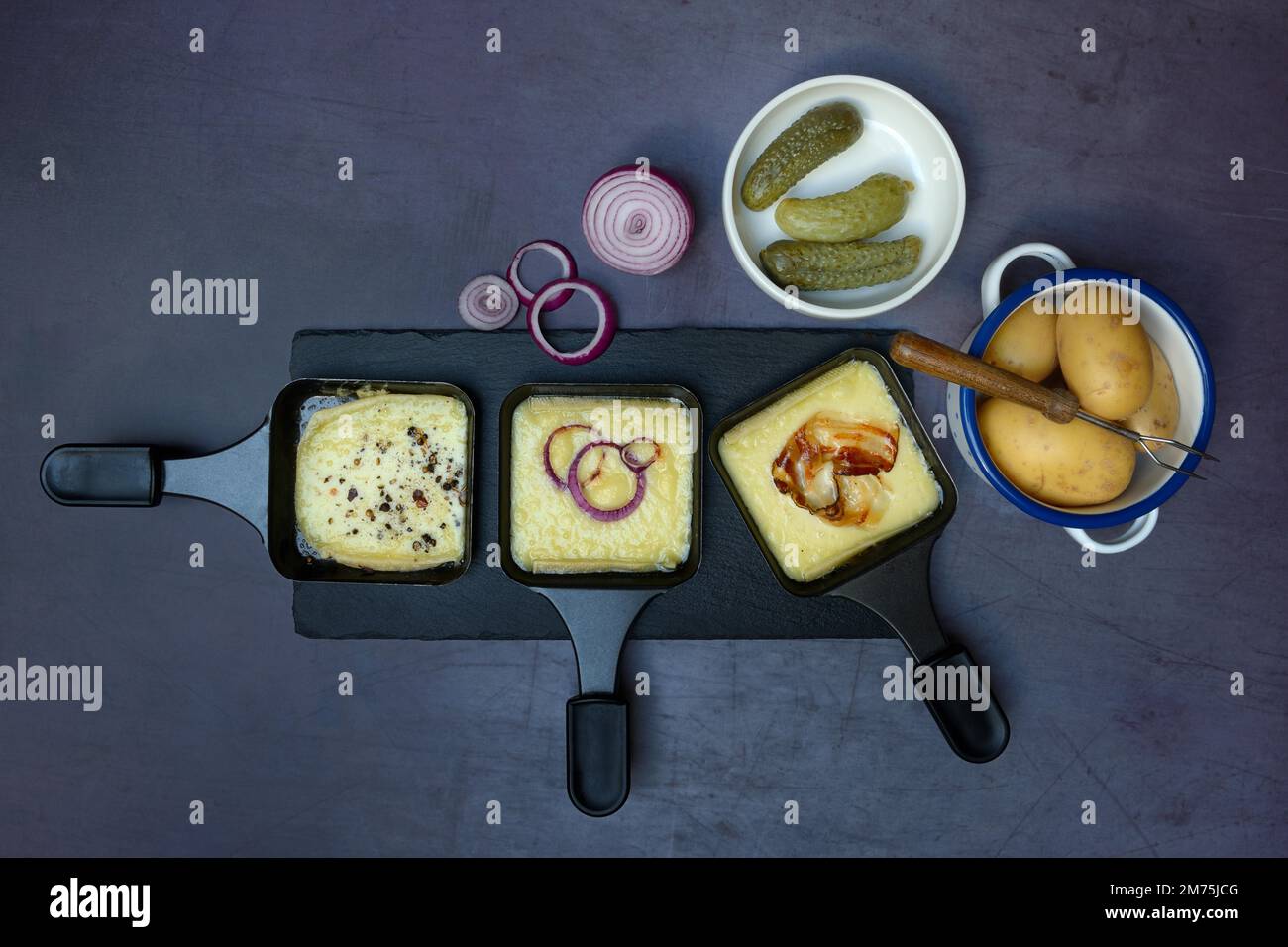 Raclette, melted raclette cheese in pans and ingredients Stock Photo ...