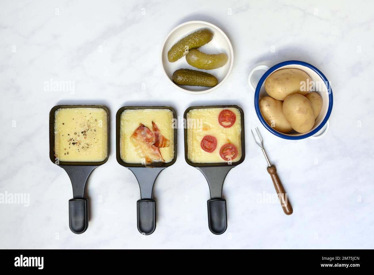 Raclette, melted raclette cheese in pans and ingredients Stock Photo ...