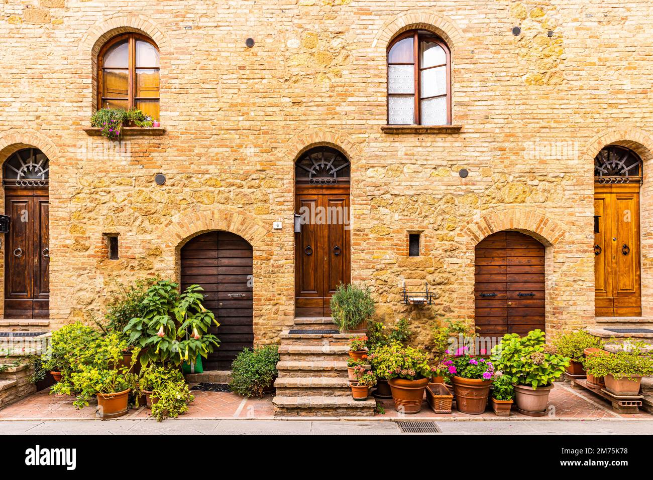 House entrances decorated with flower pots, in the centre of Pienza ...