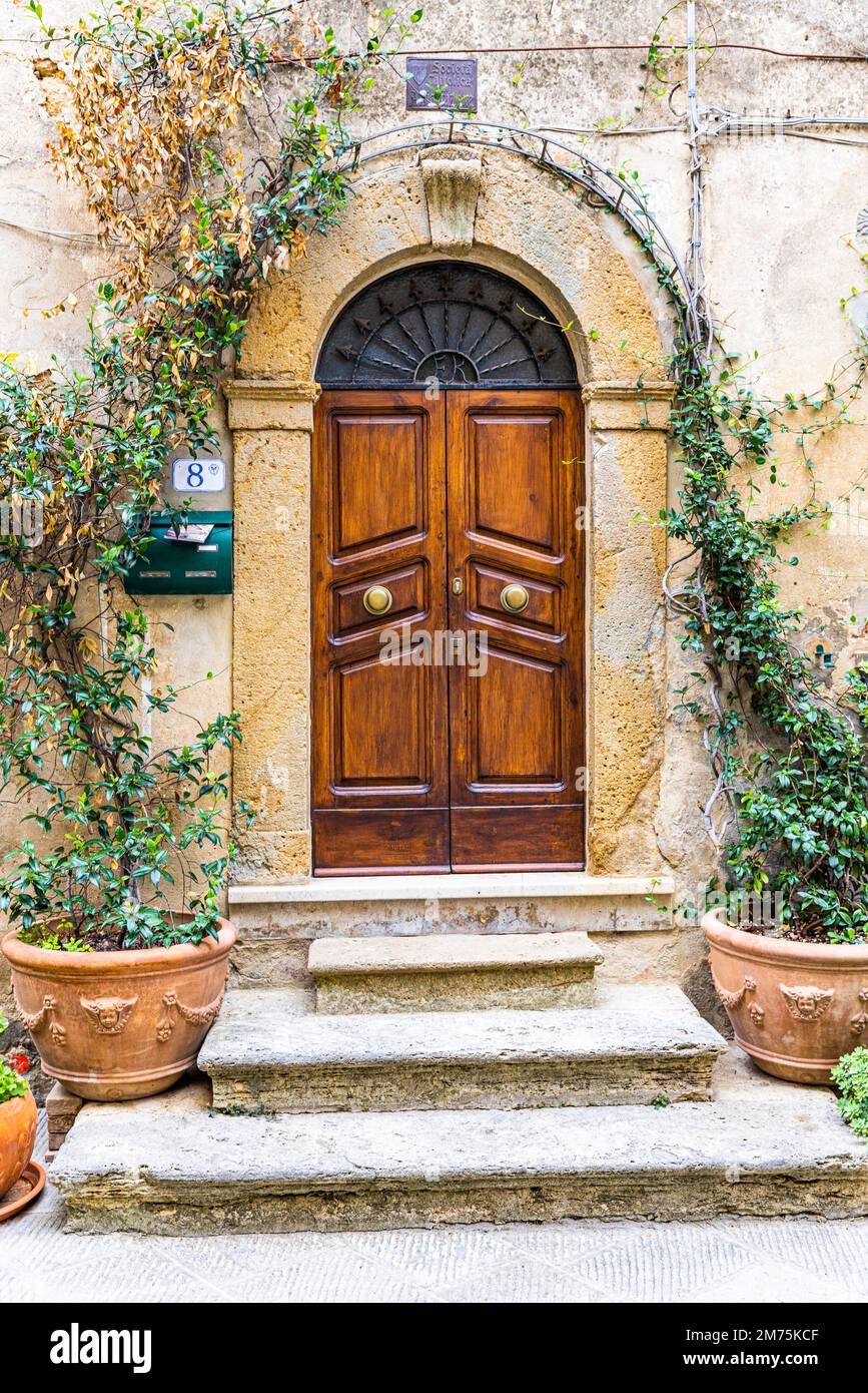 Round arched house entrance door above a stone staircase, decorated ...