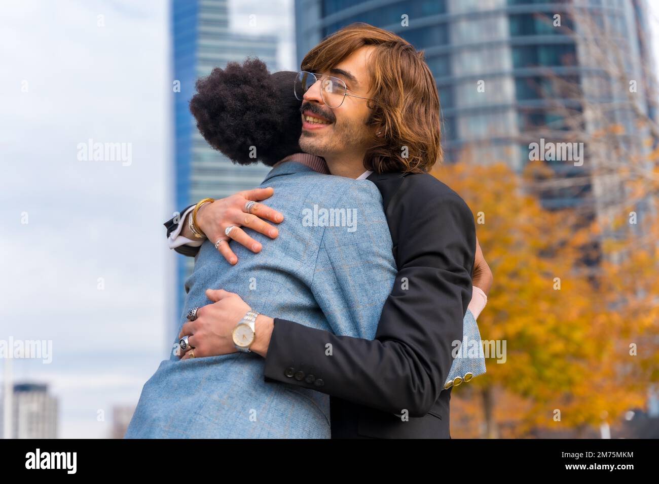 Multi-ethnic businessmen and businesswomen, hugging each other, good ...