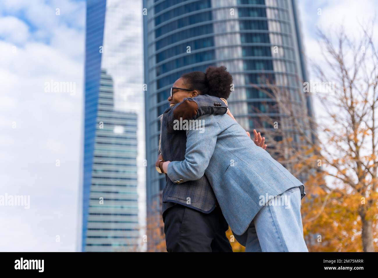 Middle-aged multi-ethnic businesswomen and executives hugging in good ...