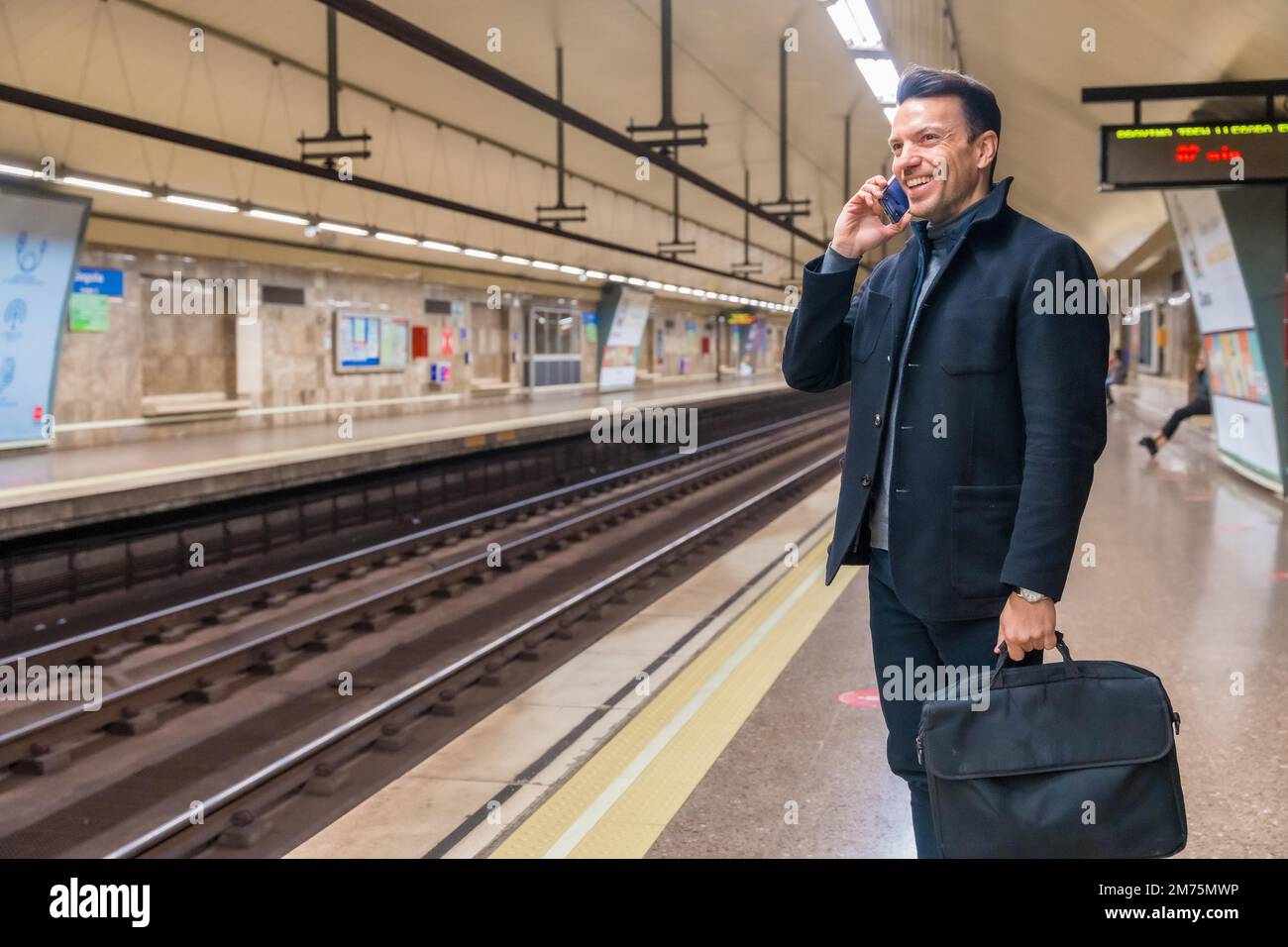 Middle-aged Caucasian businessman waiting on the subway for the train ...