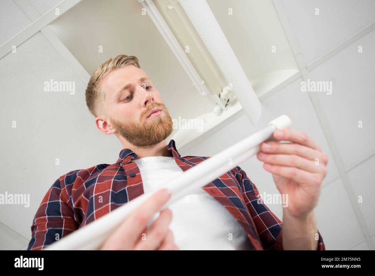 worker installing ceiling fluorescent lamp Stock Photo - Alamy