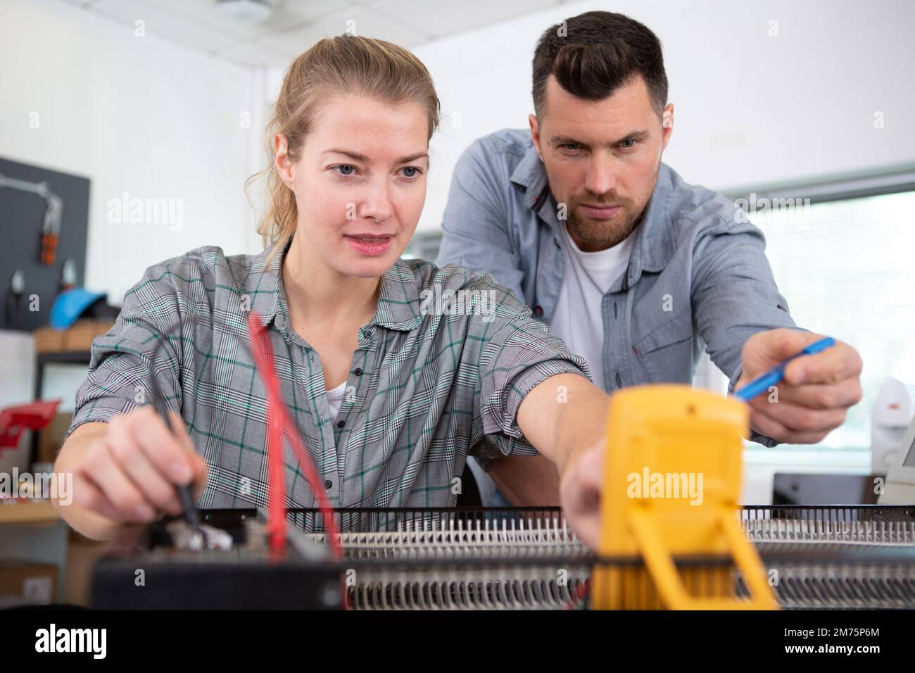 female apprentice testing electric machine Stock Photo - Alamy