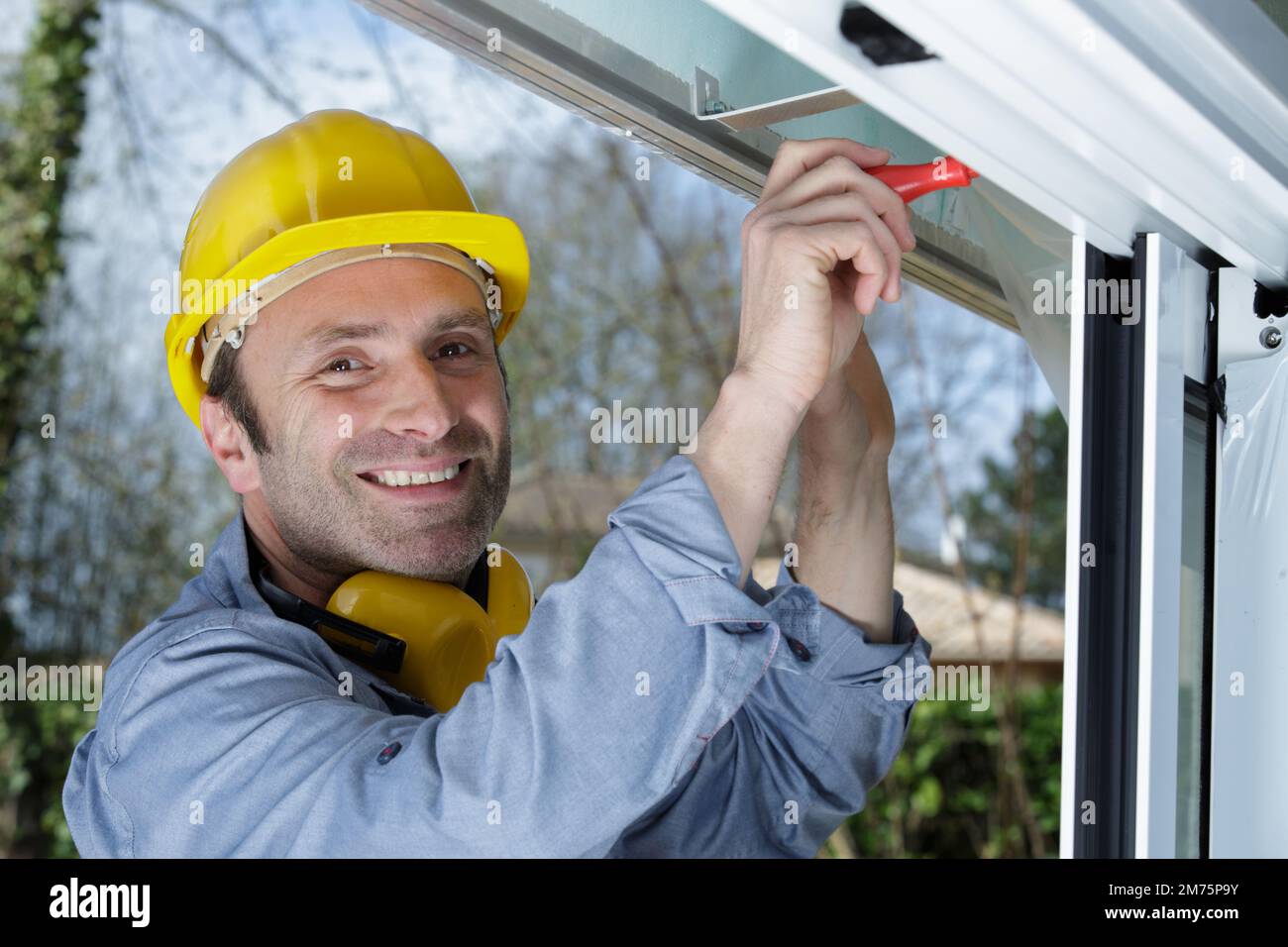 happy construction worker installing plastic window in house Stock ...