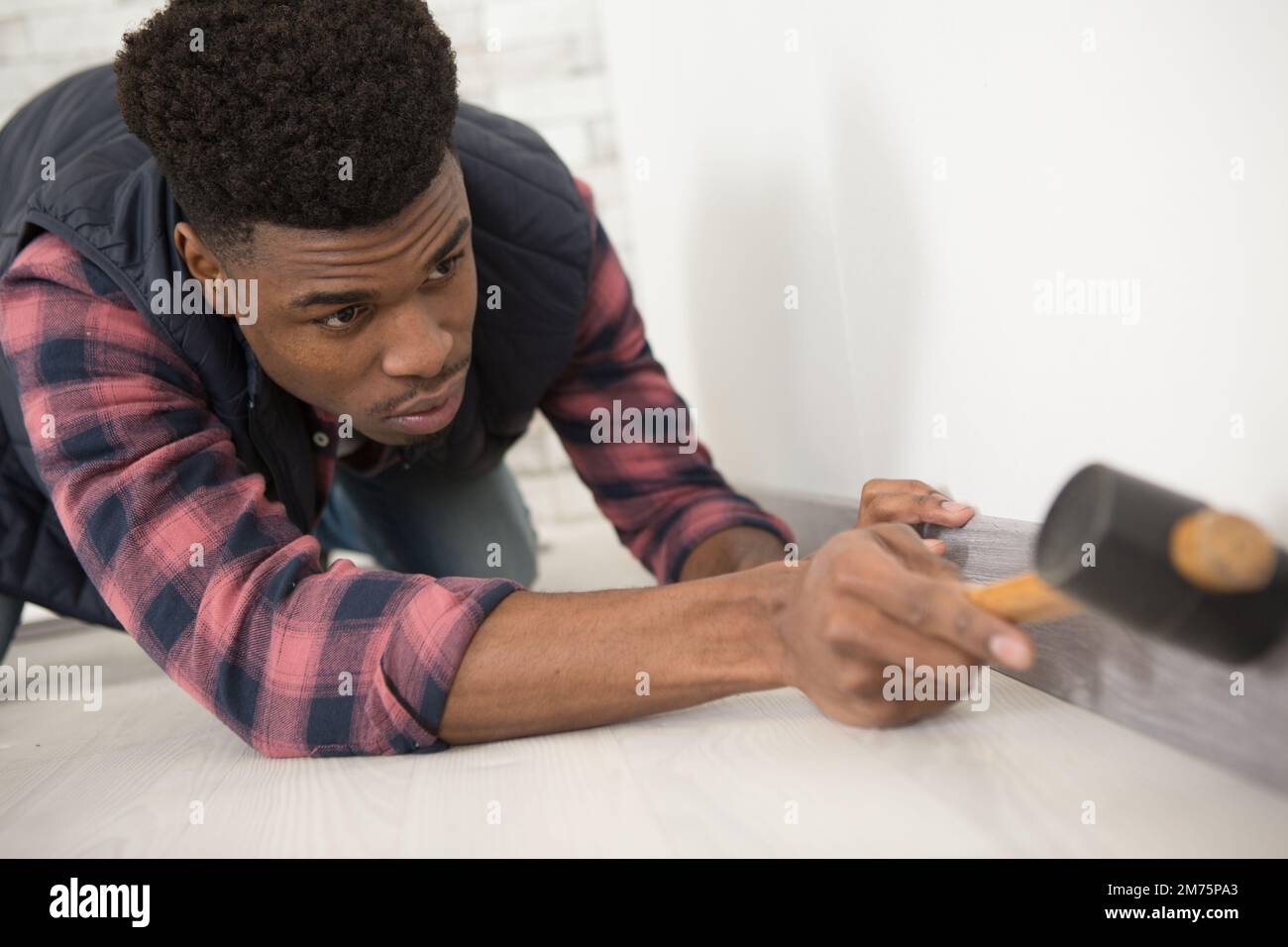 floor fitter tapping the plinth Stock Photo - Alamy