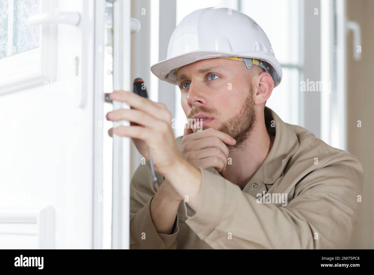 locksmith in white shirt fix white wood door Stock Photo - Alamy