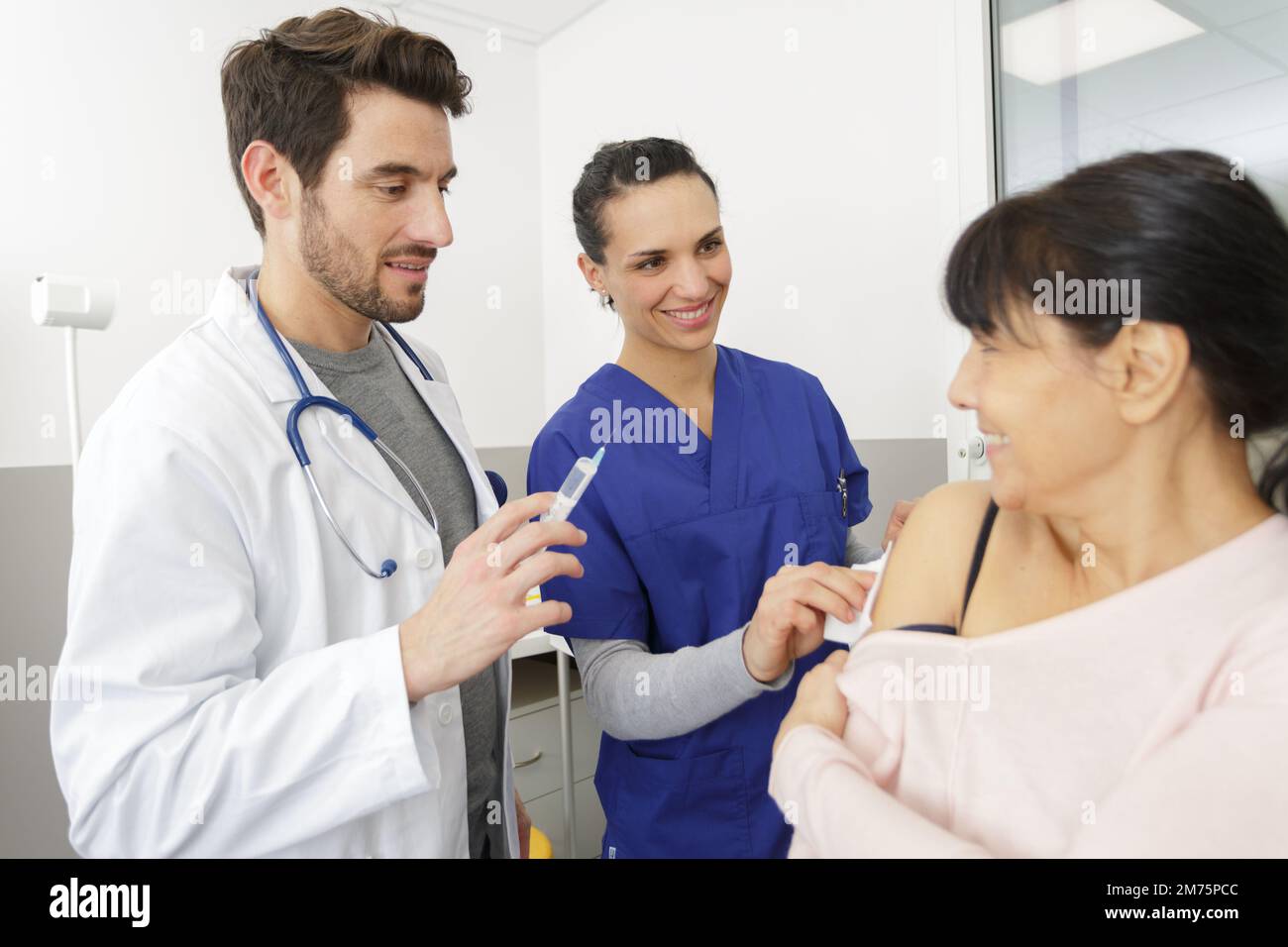male doctor injects a senior patient Stock Photo - Alamy