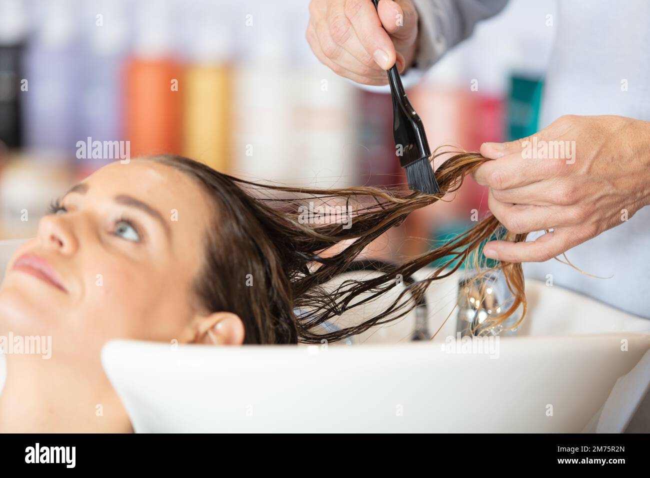 hairdresser washes customer hair in basin Stock Photo - Alamy