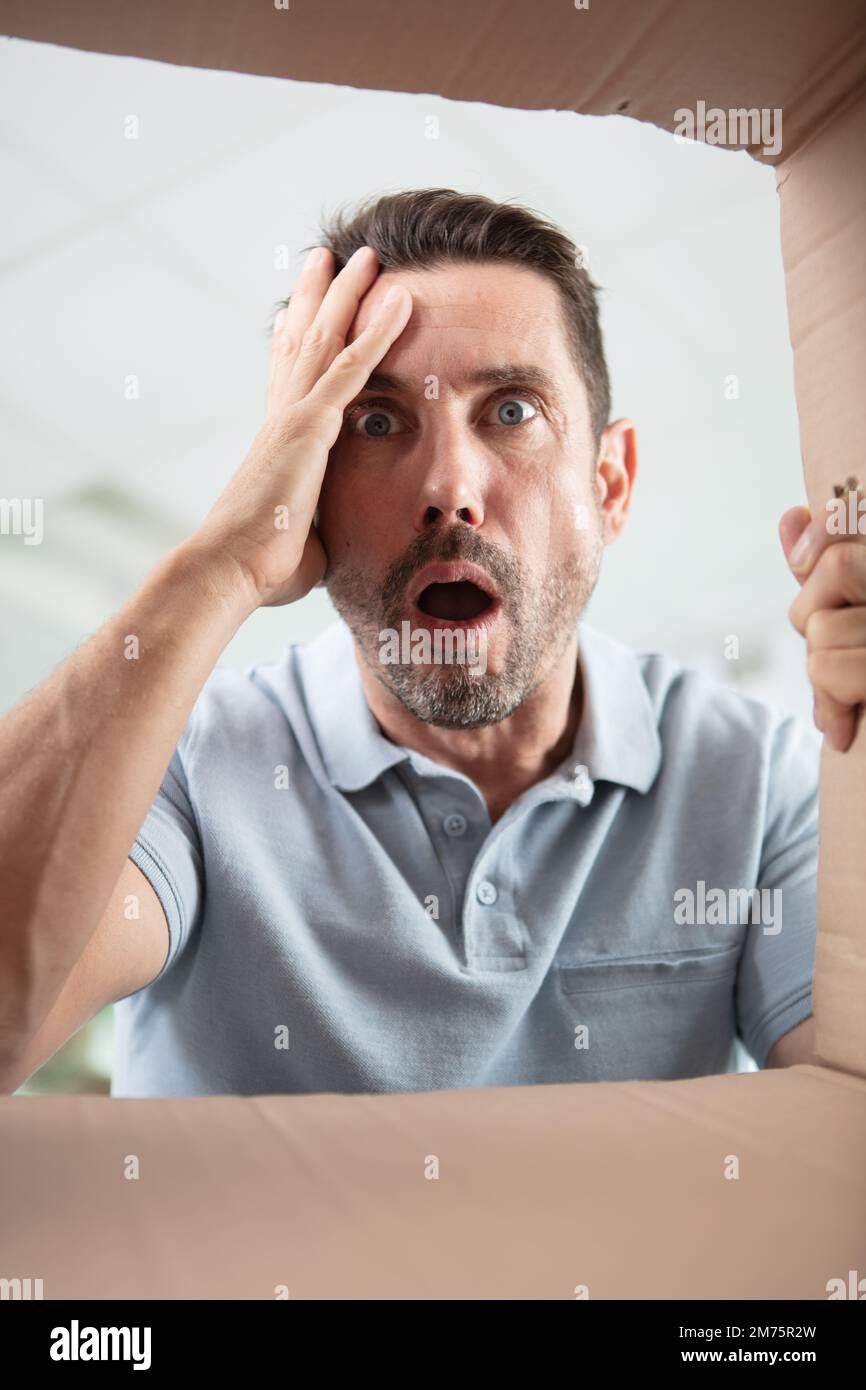 shocked guy looking into empty cardboard box Stock Photo - Alamy