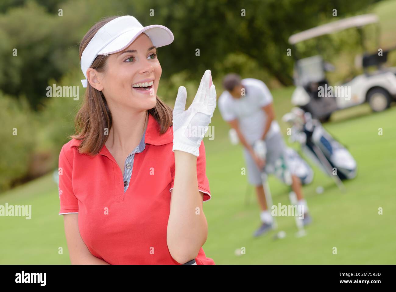 female golfer waving to somebody in the distance Stock Photo - Alamy