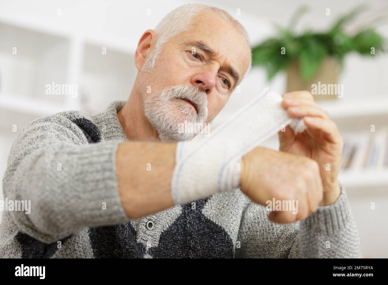 man bandaging his own hand Stock Photo - Alamy
