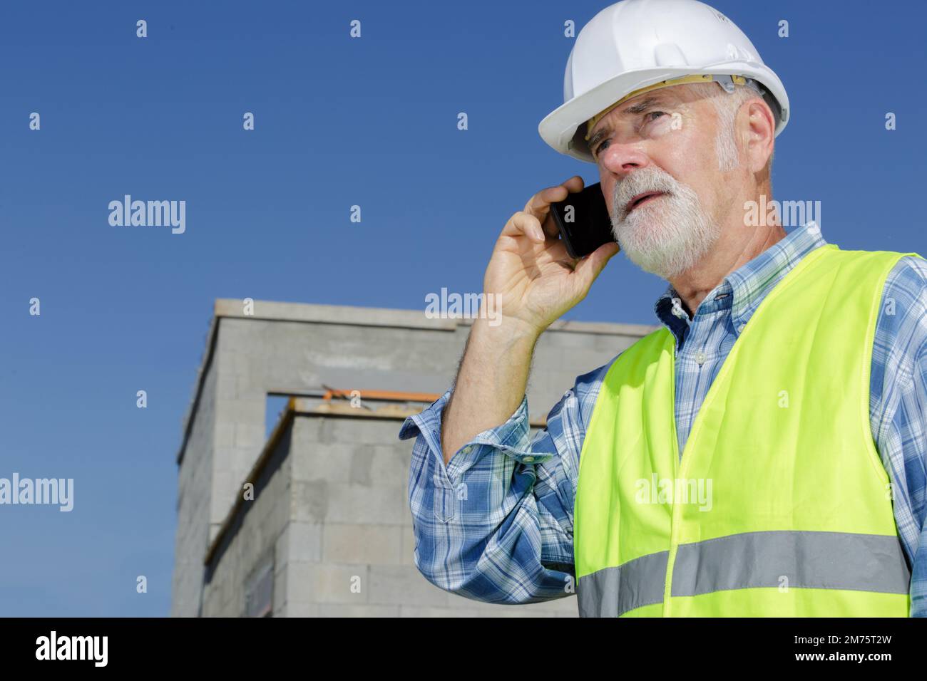 builder on construction site uses a mobile phone Stock Photo - Alamy