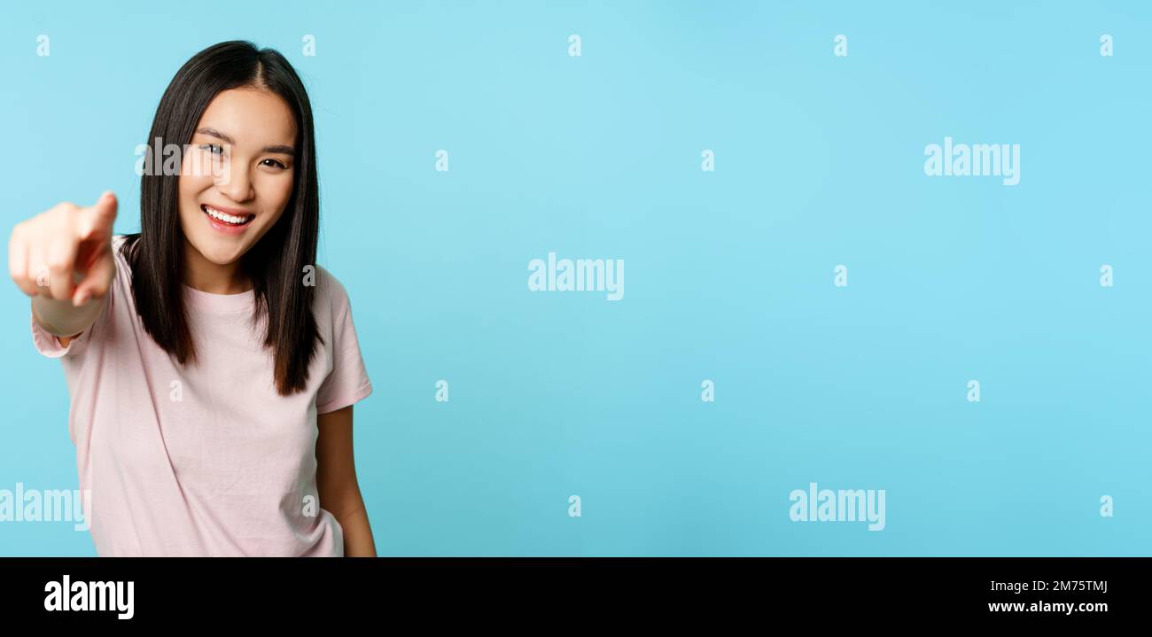 Its you. Smiling happy asian woman pointing finger at camera ...