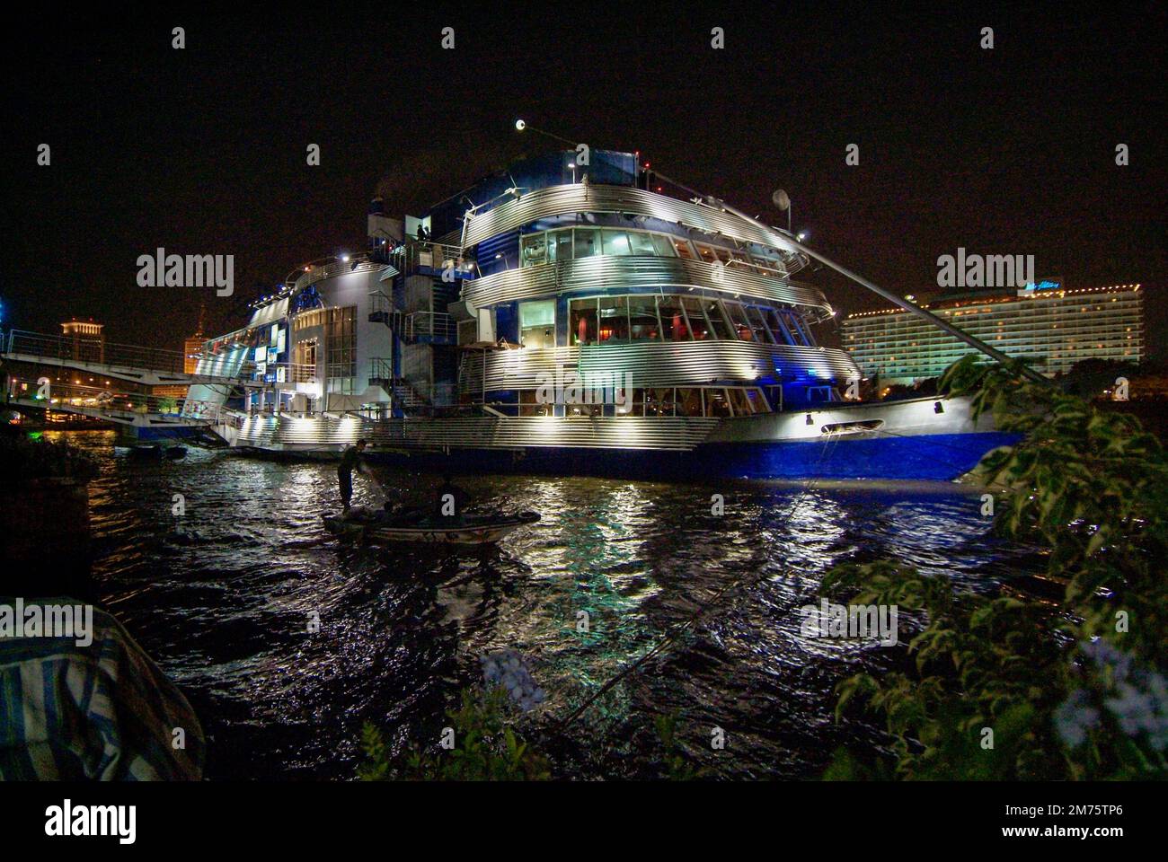 Some kind of pleasure boat on the Nile River in Cairo and a hotel on ...