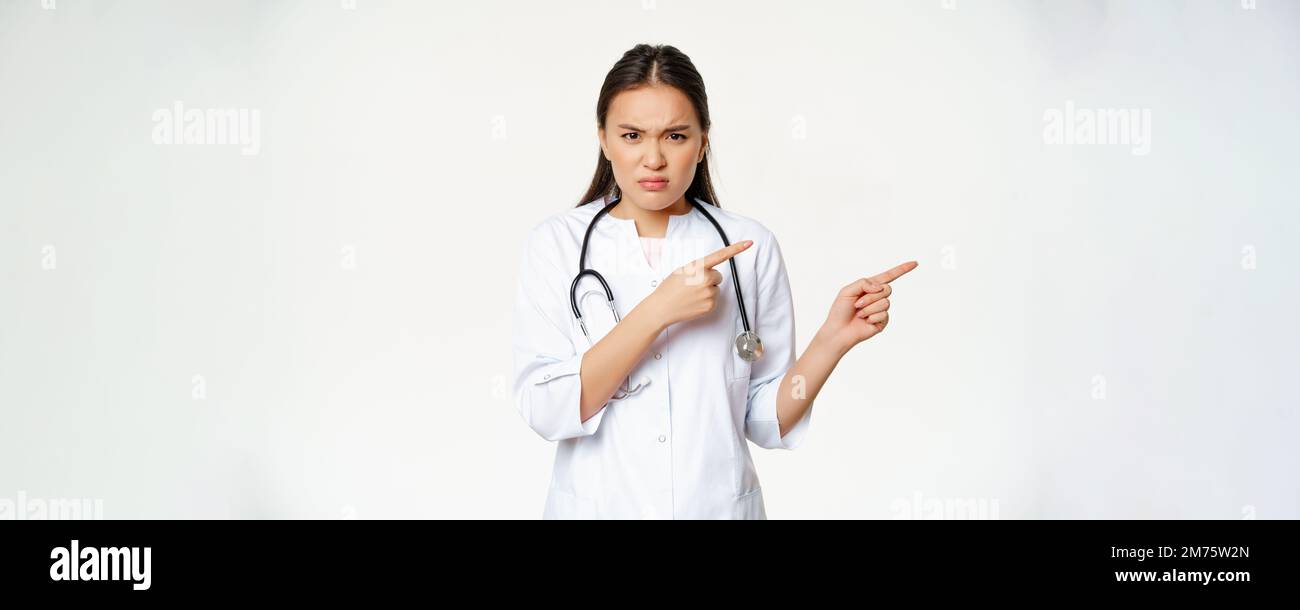 Angry female doctor, asian physician in medical robe and stethoscope ...