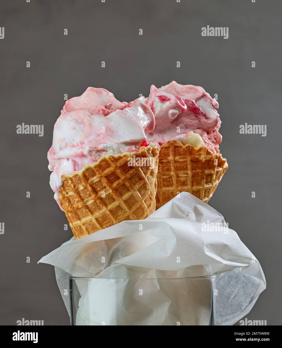 two ice cream cones in a glass on grey background Stock Photo - Alamy