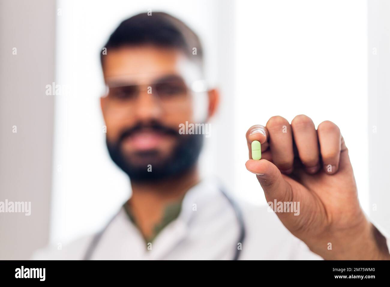 doctor wearing uniform and showing a pill in hand blurred person Stock ...