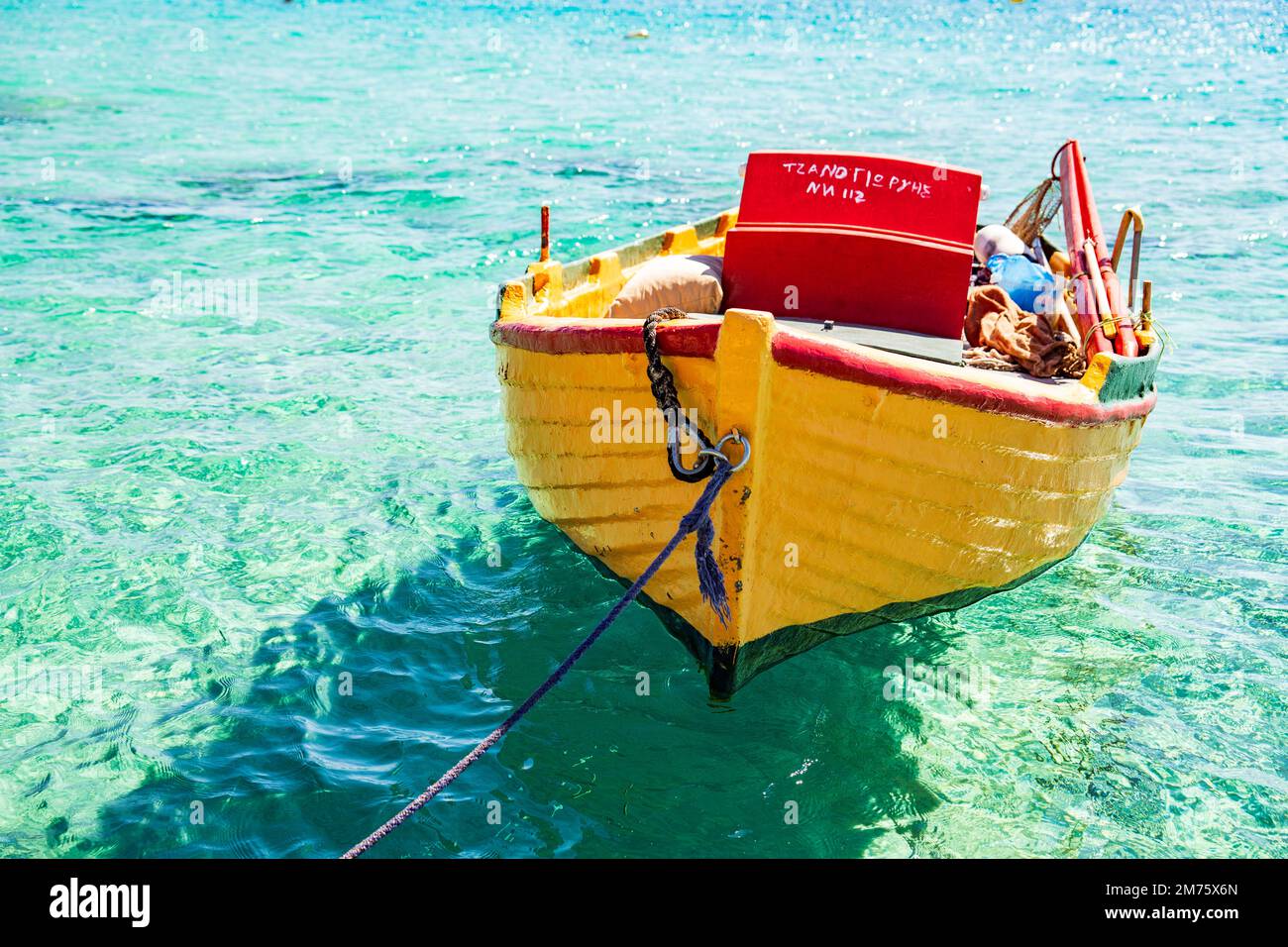 Koufonissi, Cyclades islands, Greece. A yellow fishing boat floats ...