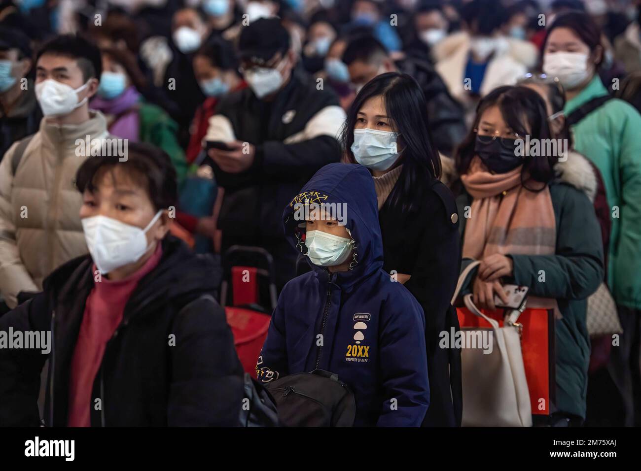 Passengers wearing face masks line up to board a train at Hankow ...