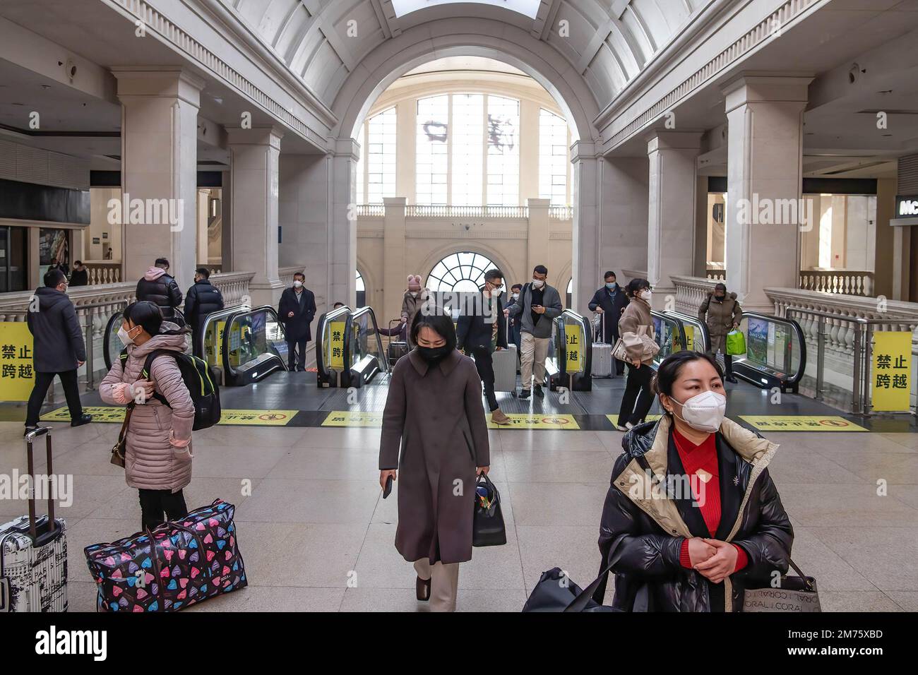 Passengers wearing face masks carry their luggage at the Hankow Railway ...