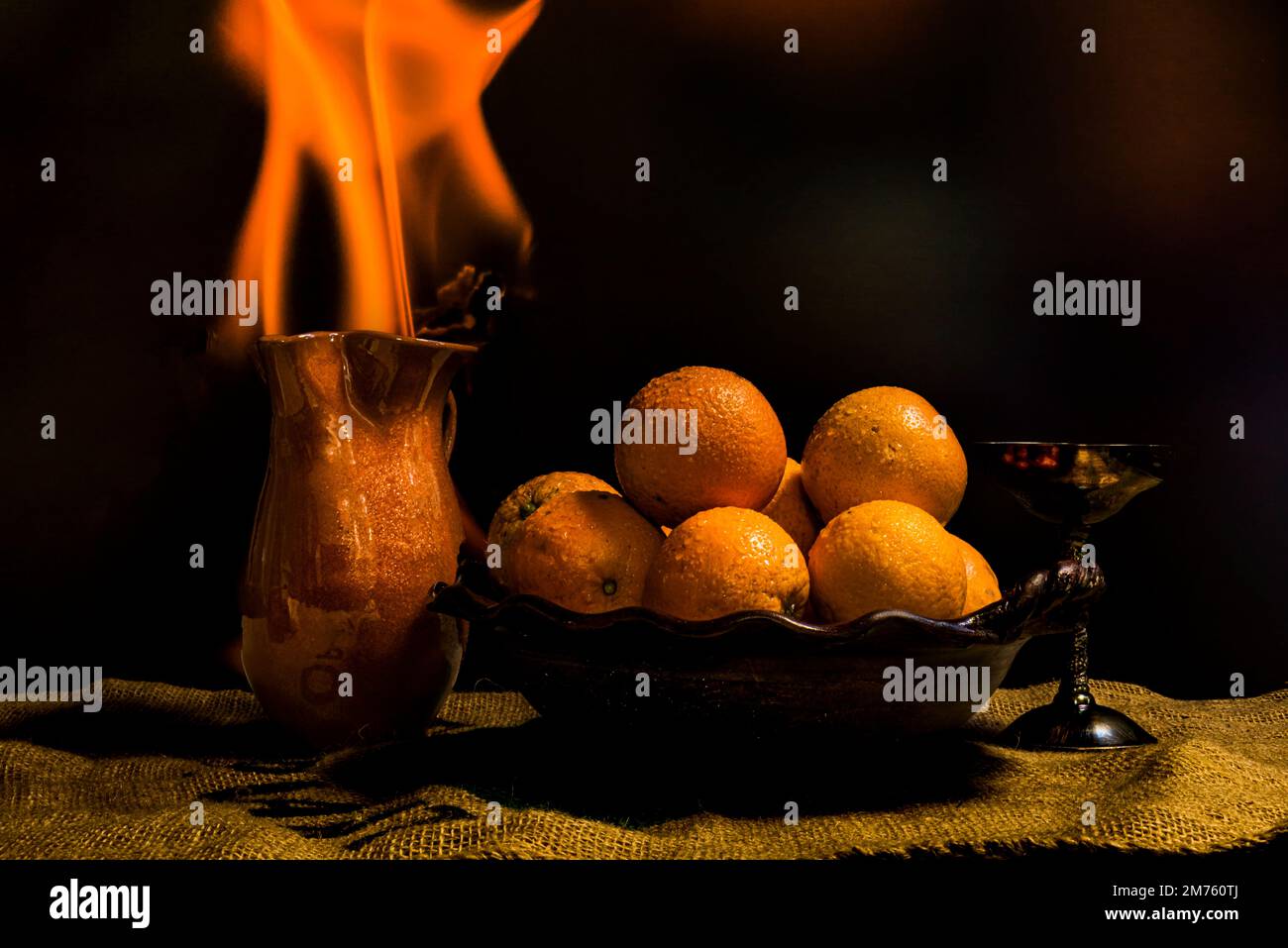 image of a still life of orange colored fruit with a jug full of fire ...
