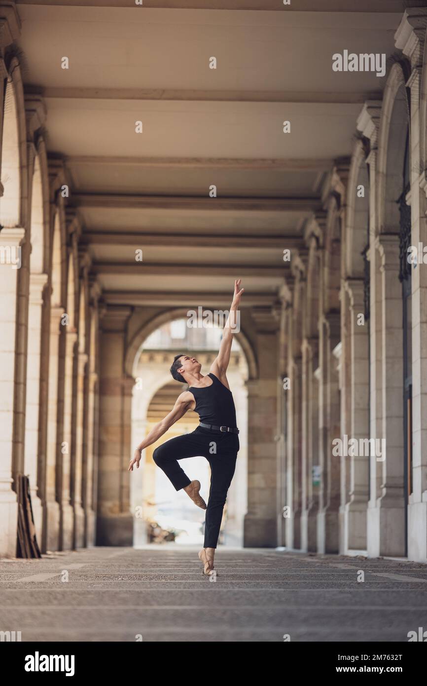Young man dancing classic ballet in the streets of Barcelona with a ...