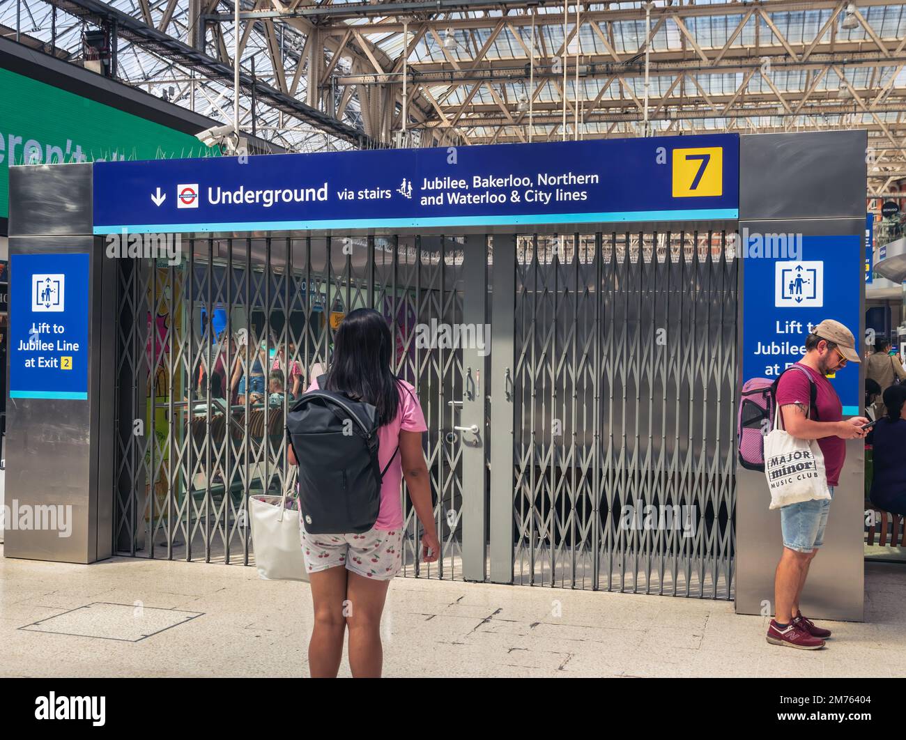 girl looking at the closed Entrance gate to the Underground station in ...
