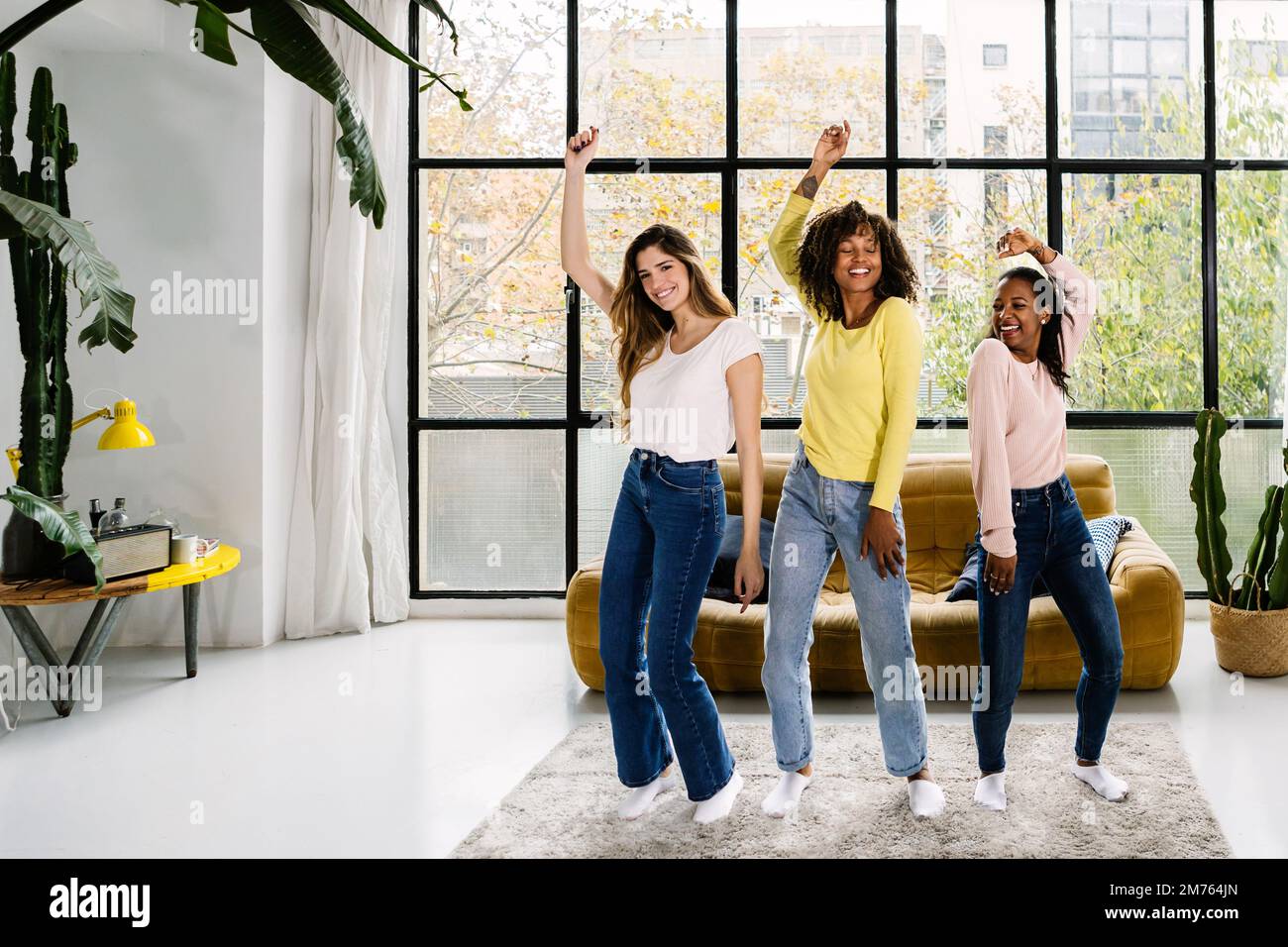 Three multiracial young women friends having party at home Stock Photo ... Three multiracial young women friends having party at home Stock Photo ...