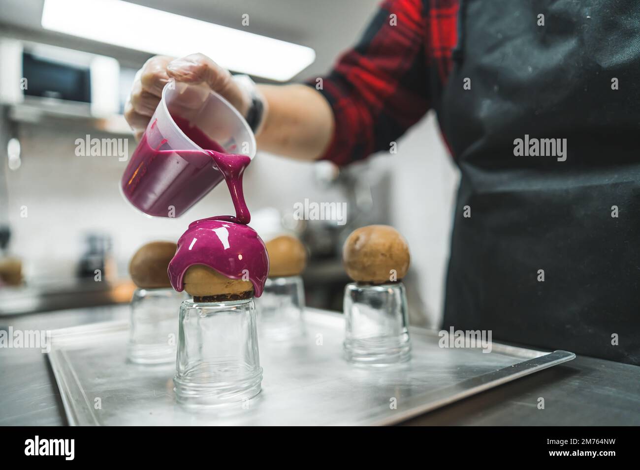Decorating sweets. Unrecognizable caucasian person pouring magenta pink ...