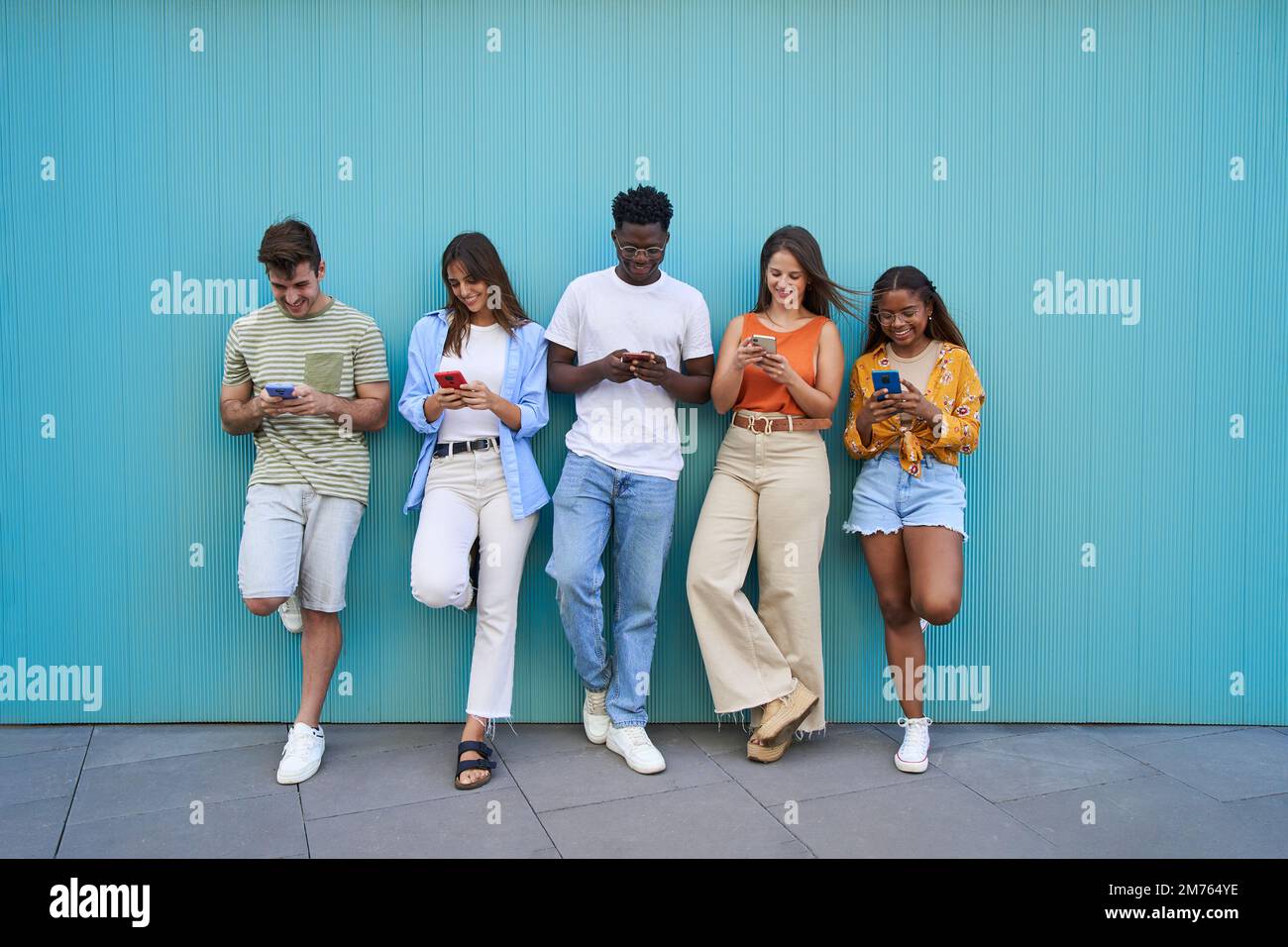 Multicultural group of friends using cell phones Stock Photo - Alamy