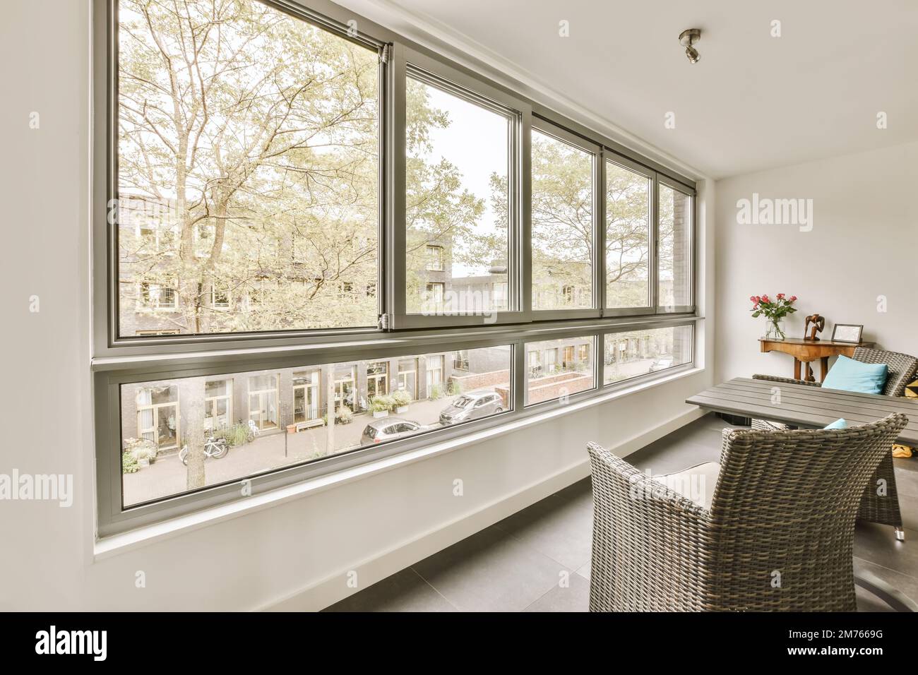 a living room with a table, chair and large window looking out onto the ...