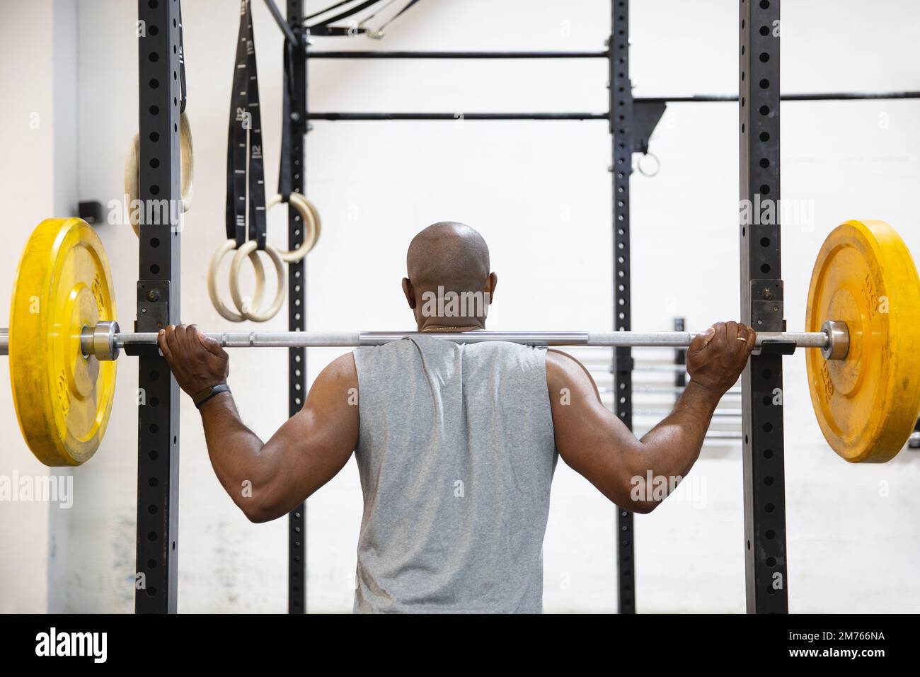 Back view of African American male athlete working out with weights ...