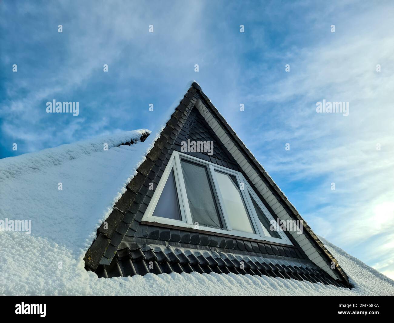 Open roof window in velux style with snow convered black roof tiles ...