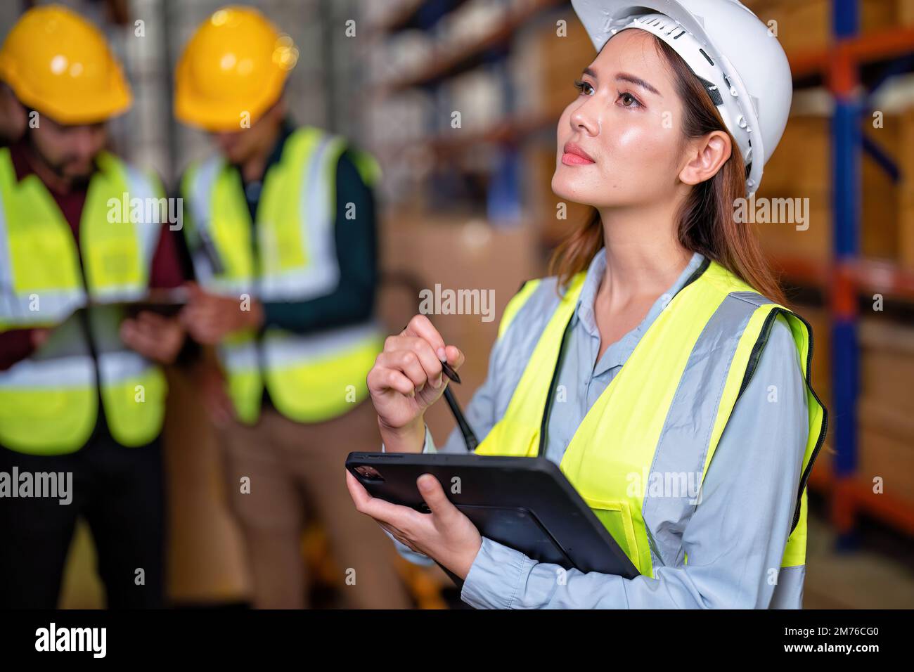 Worker in warehouse holding check list tablet pc stand portrait photo ...