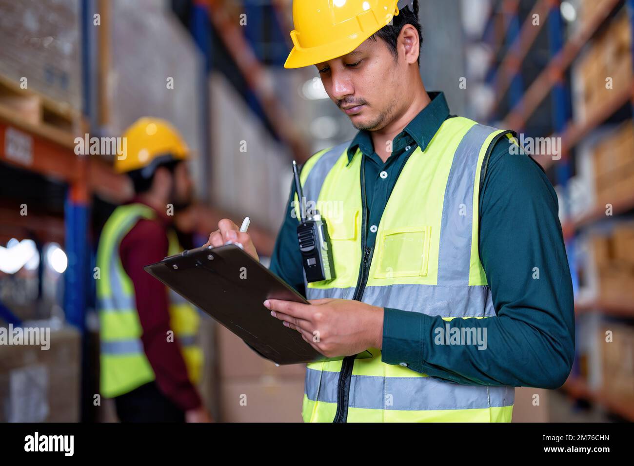 Worker in warehouse holding check list tablet pc stand portrait photo ...