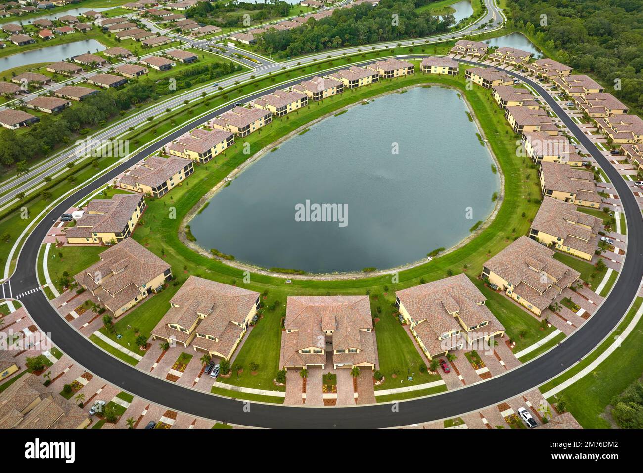 Aerial view of tightly located family houses with retention ponds to ...