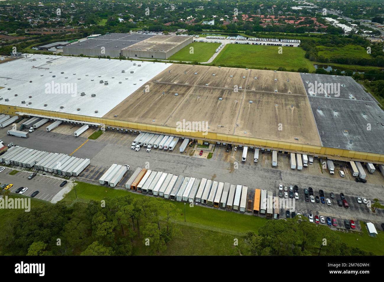 Big corporate shipment center with many cargo semi trucks unloading and ...