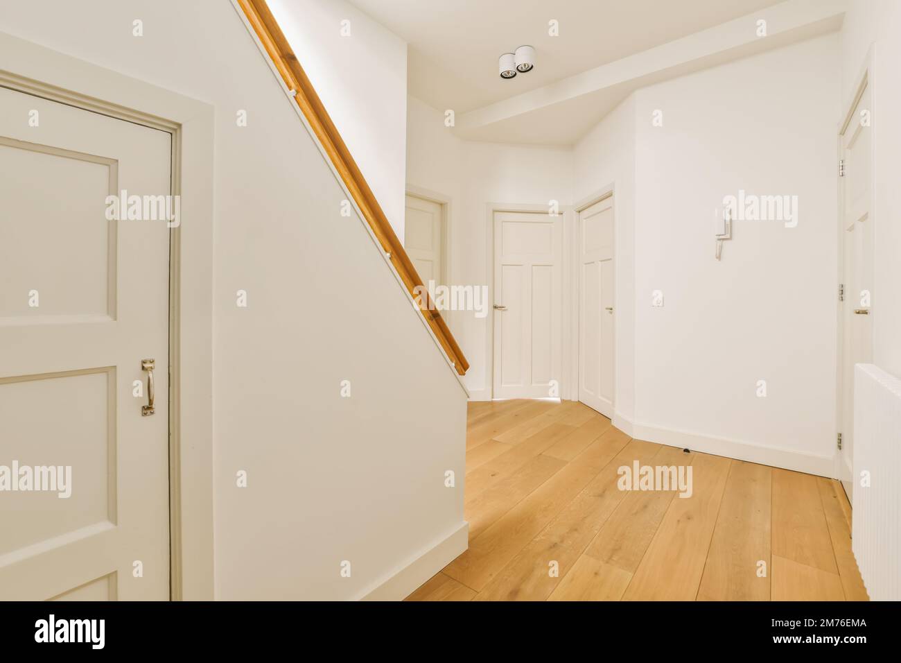 an empty room with white walls and wood flooring the door is in front ...