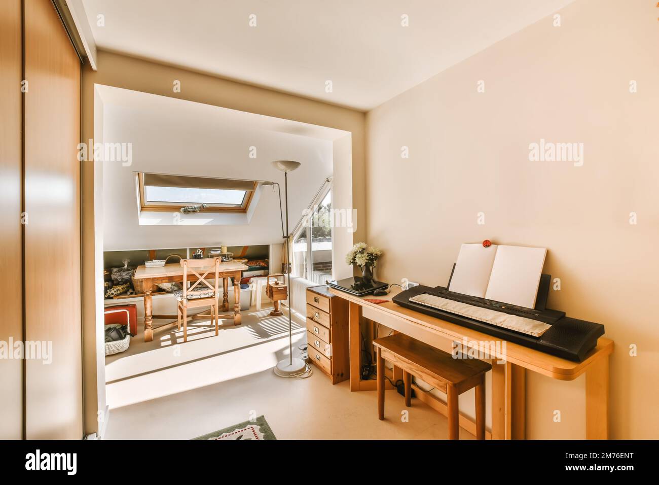 a living room with a computer on the desk and an open door that leads ...