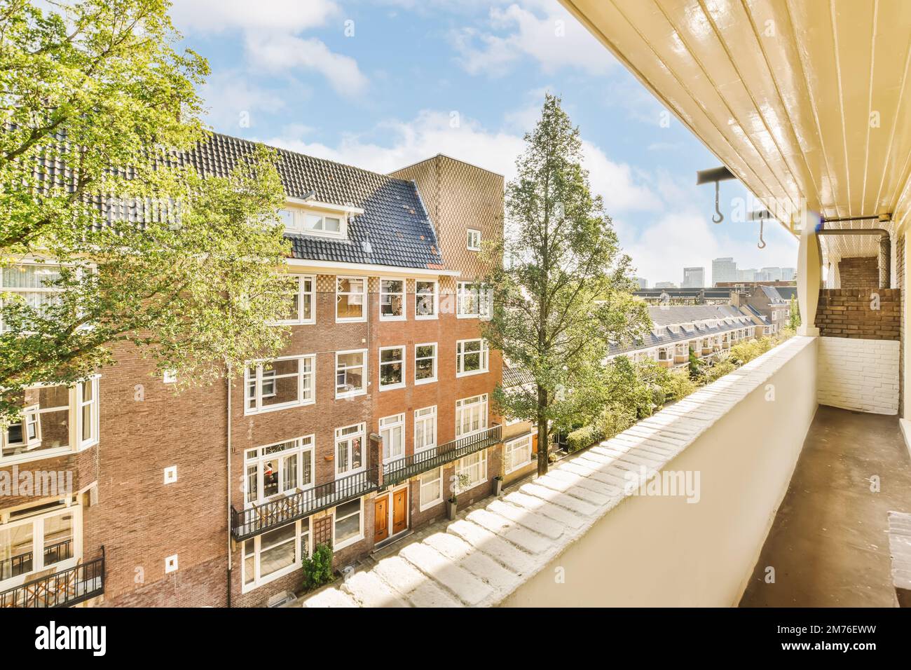 a balcony with trees and buildings in the background, taken from an ...