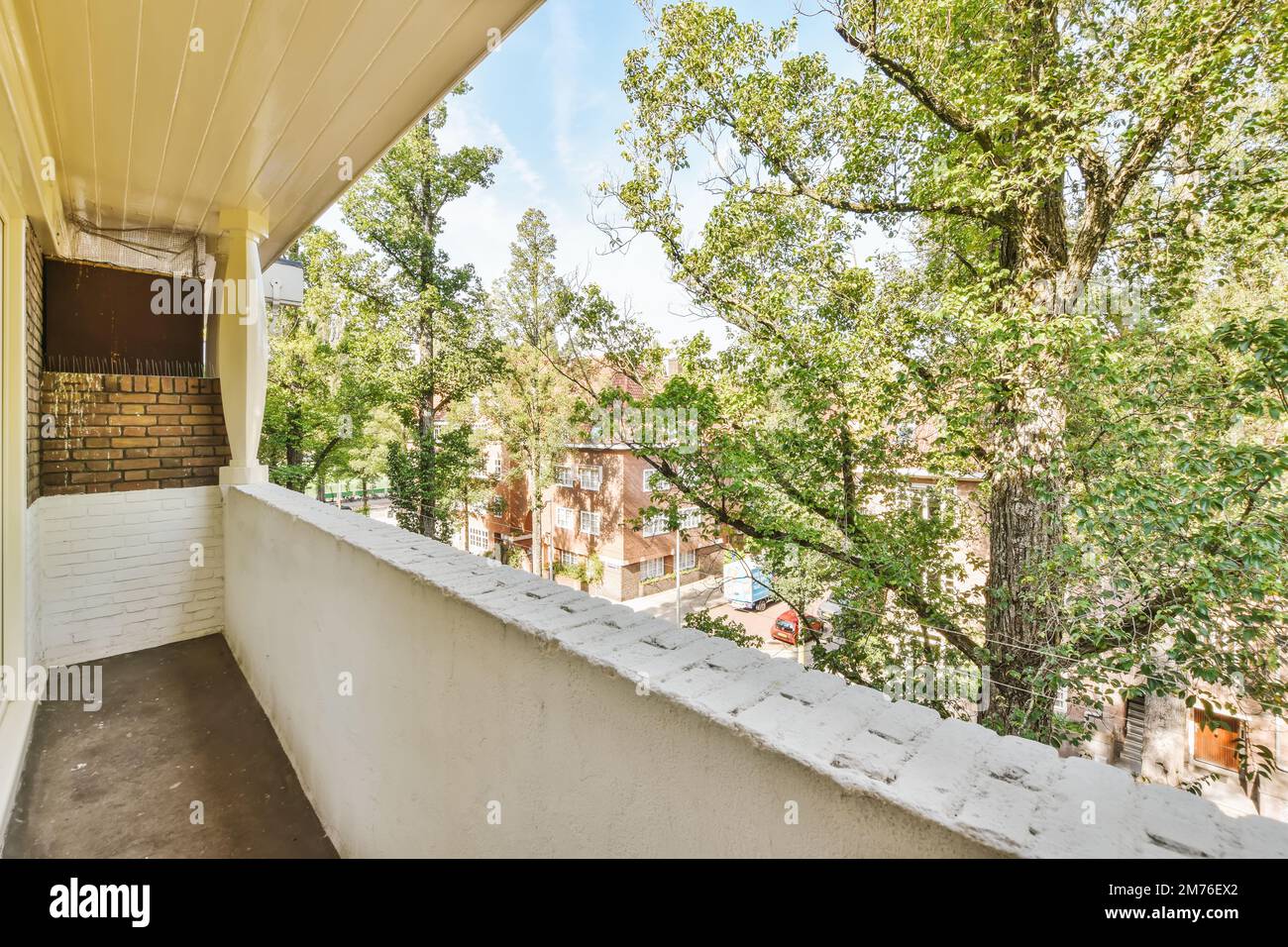 a balcony with trees and houses in the background, taken from an ...