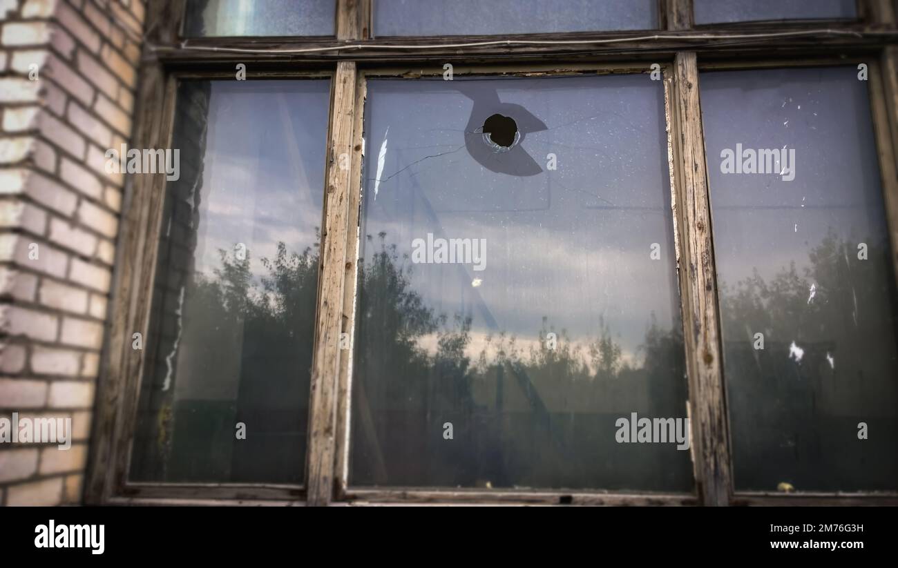 hole in the window pane of an old house. Glass broken by hooligans with ...